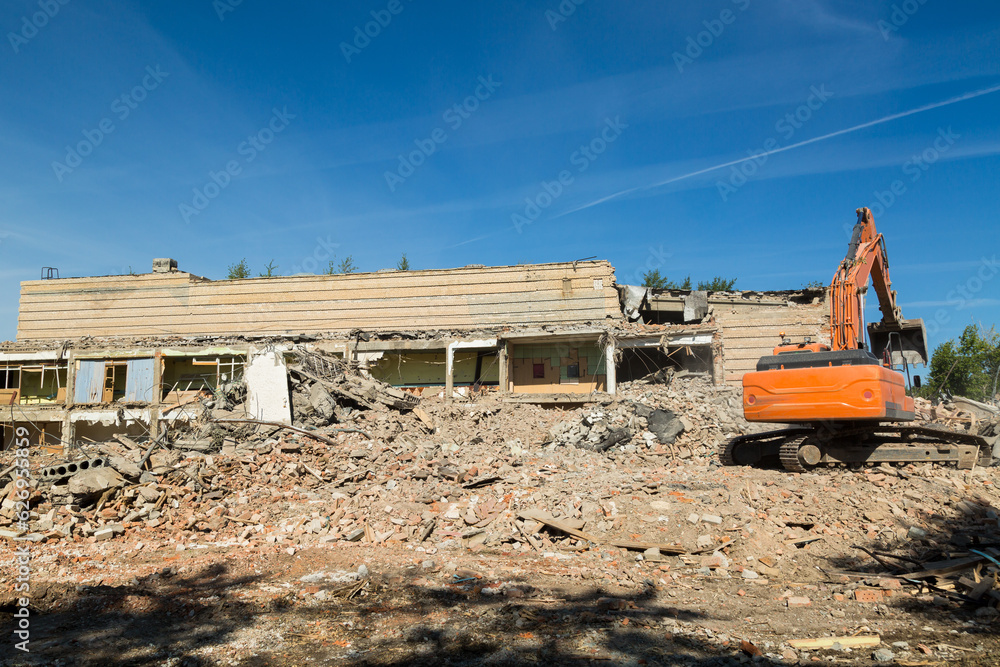 excavator eliminates consequences of an earthquake, clearing rubble ...