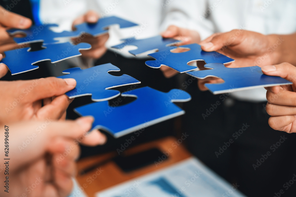 Multiethnic business people holding jigsaw pieces and merge them ...