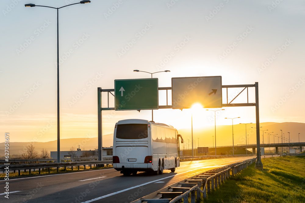 White Modern comfortable tourist bus driving through highway to bright ...