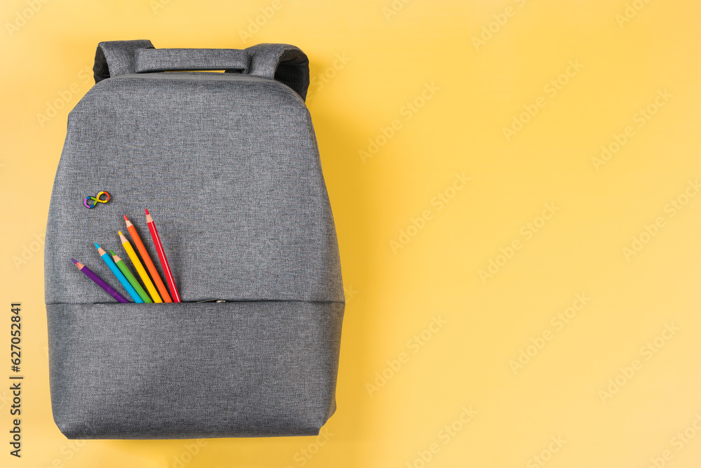 Gray backpack with autism infinity rainbow symbol sign, colored pencils ...