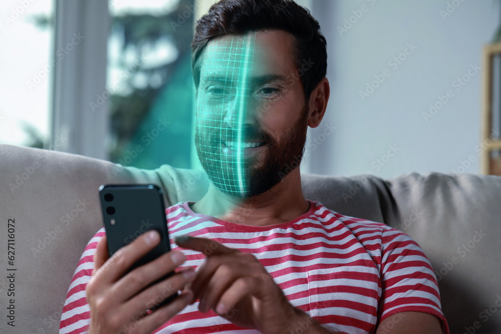 Man Using Smartphone With Facial Recognition System At Home Security Application Scanning His