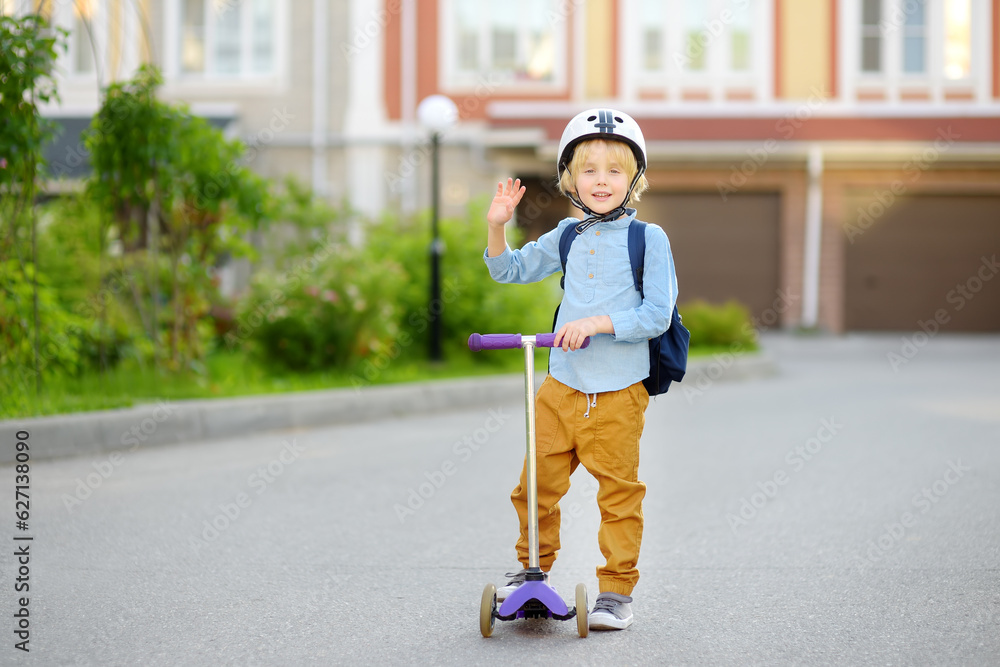 Little child in safety helmet riding scooter to school. Preschooler boy ...