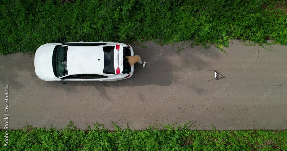 Video Stock A young man takes a spare tire out of the trunk of the car ...
