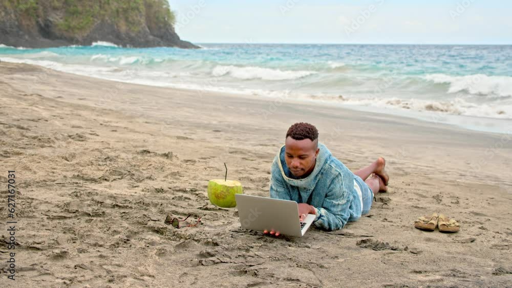 Male freelancer work near ocean. African american guy use macbook ...