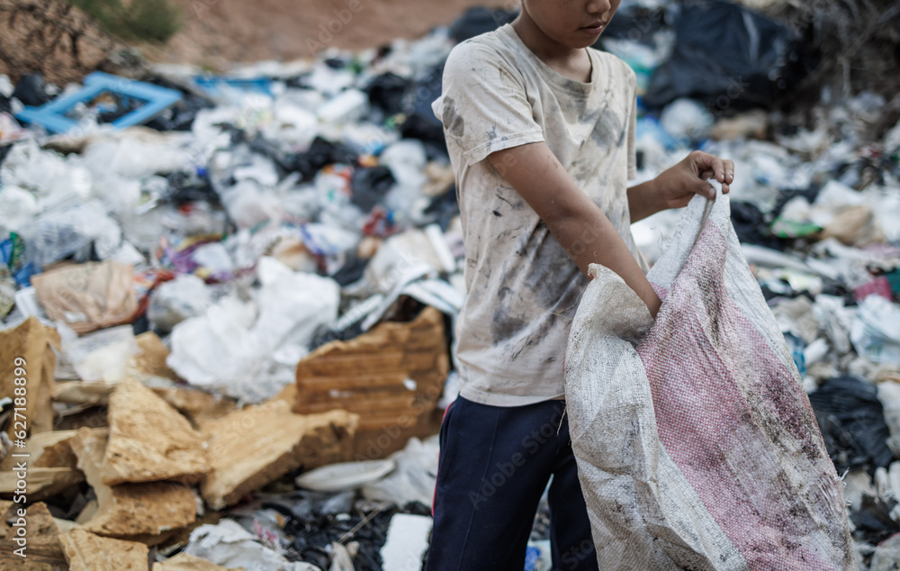 Foto de Poor boy collecting garbage in his sack to earn his livelihood ...