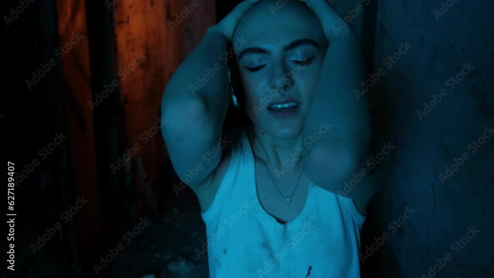 A woman with no hair on her head in a neon-lit basement is drawn behind ...