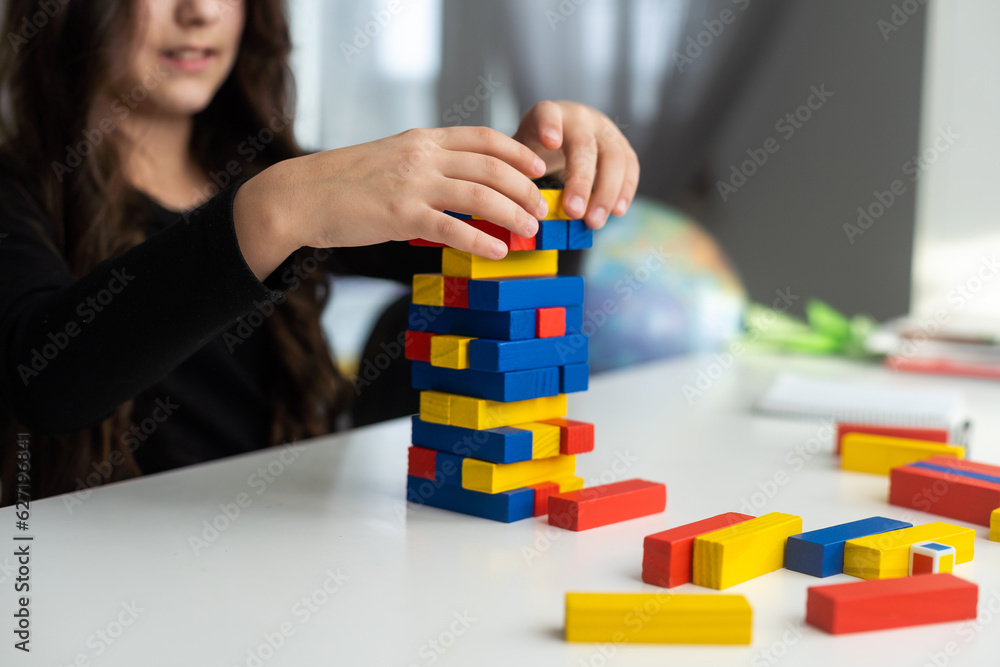 Children building wood blocks at playground. Girl kid playing stacking ...