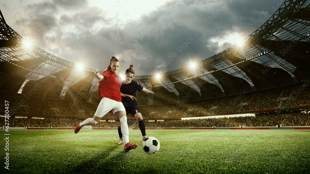 Two competitive women, football players in motion during match, game ...