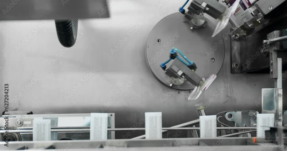 Manufacturing line at medical factory. Robotic arm put medicine package ...