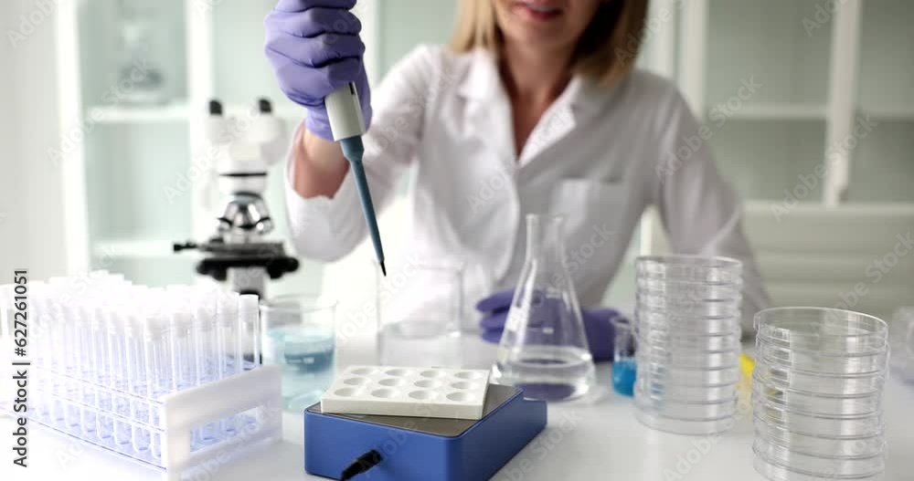 Scientist with pipette analyzes liquid to extract DNA and molecules in ...