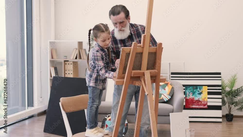 Close up view of senior grandfather and little child in similar outfits ...