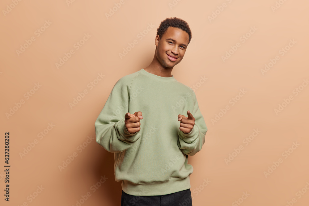 Hey you. Positive dark skinned African man with short hair makes finger ...