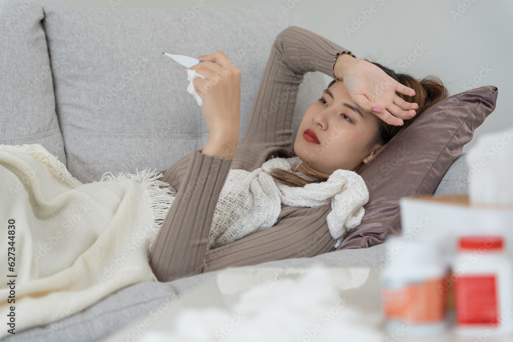 Young Asian woman having high fever while checking body temperature ...