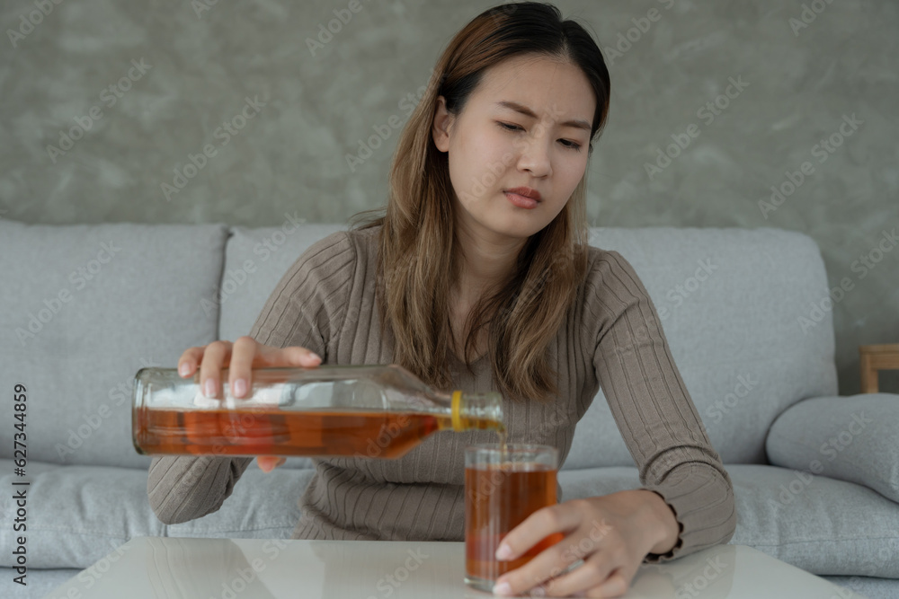 Depressed young Asian woman addicted feeling bad drinking whiskey alone ...