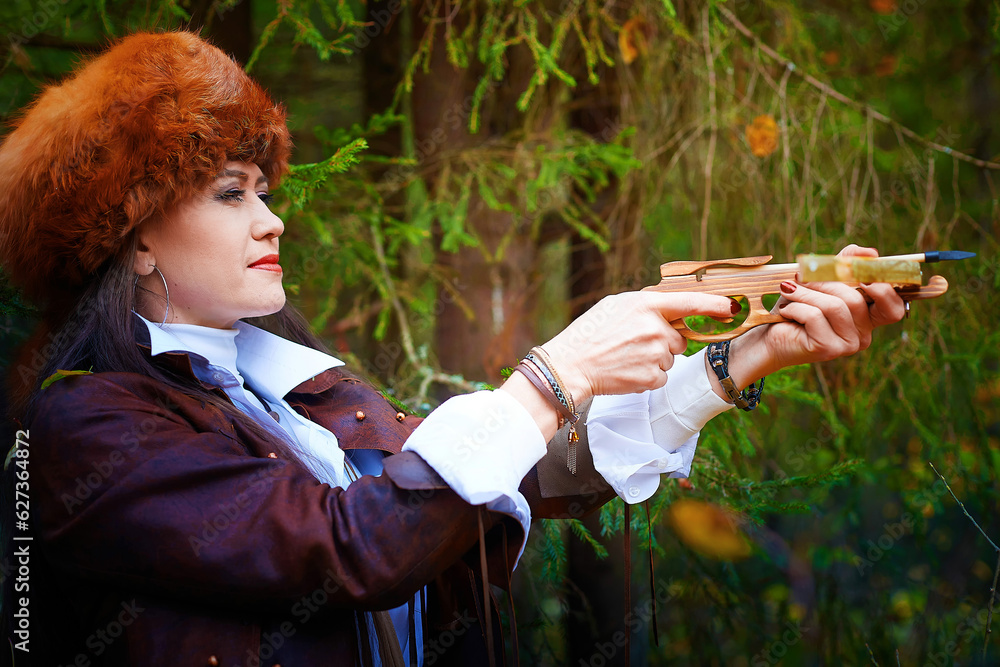 Girl in a leather jacket, a big red fox fur hat and with a crossbow in ...
