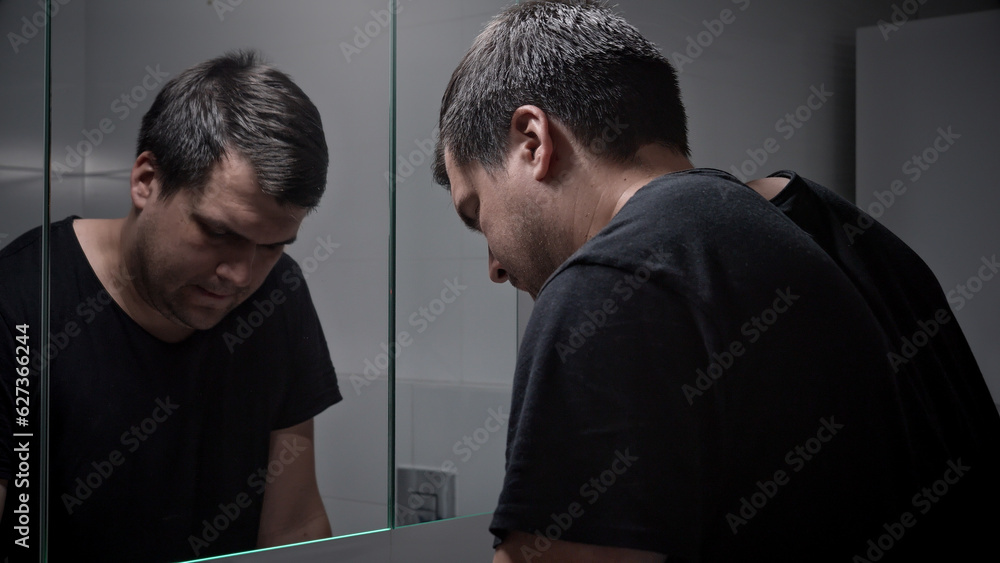 Upset lonely man suffering from depression looking in reflection at ...