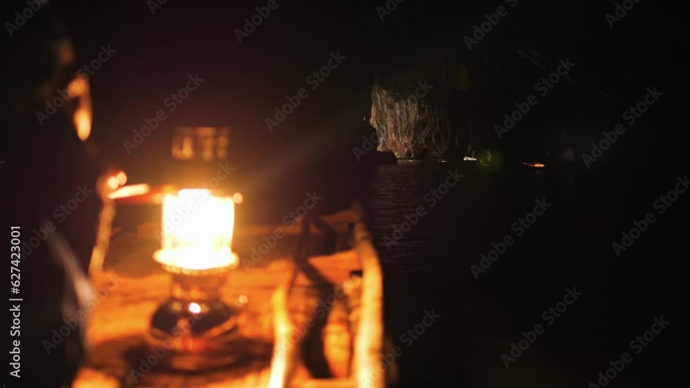 Bamboo raft with a burning lantern floats through natural limestone ...