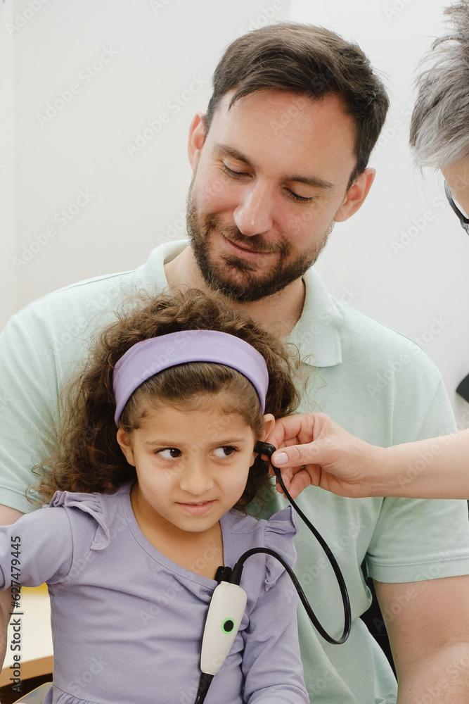 Child hearing test. Doctor audiologist examining kids ear and assess ...