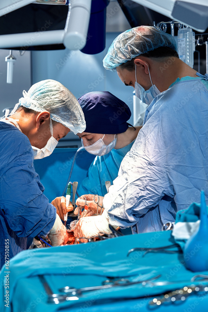 Surgeons team during complex surgical operation in a sterile operating ...