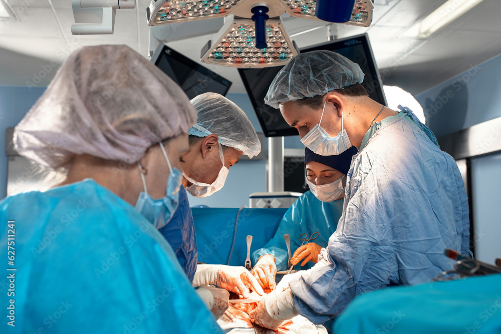 Surgeons team during complex surgical operation in a sterile operating ...