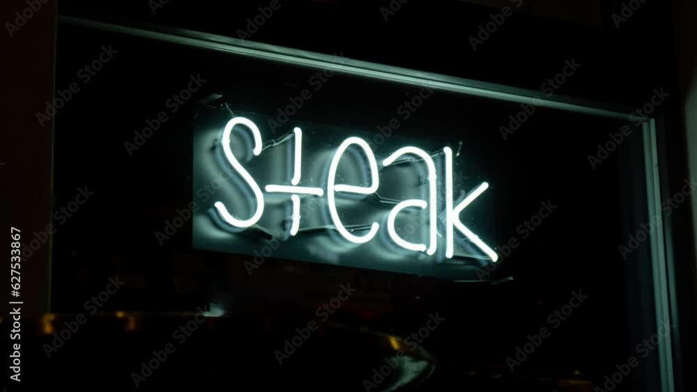 Zoom in out Steak inscription in neon lights at night. Electric sign at ...