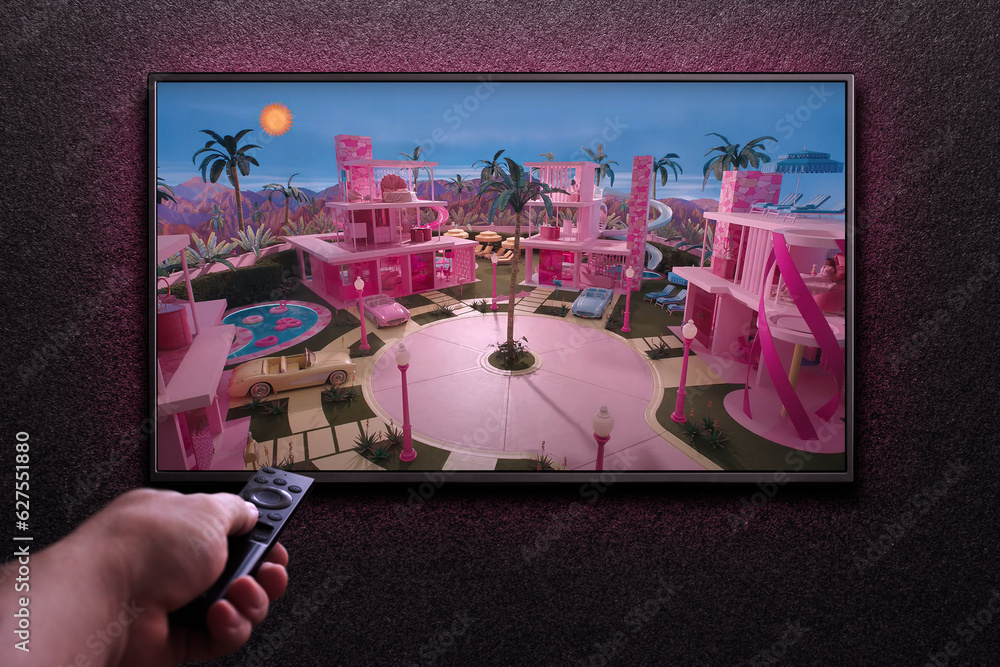 TV screen playing Barbie trailer or movie. Man turns on TV with remote ...