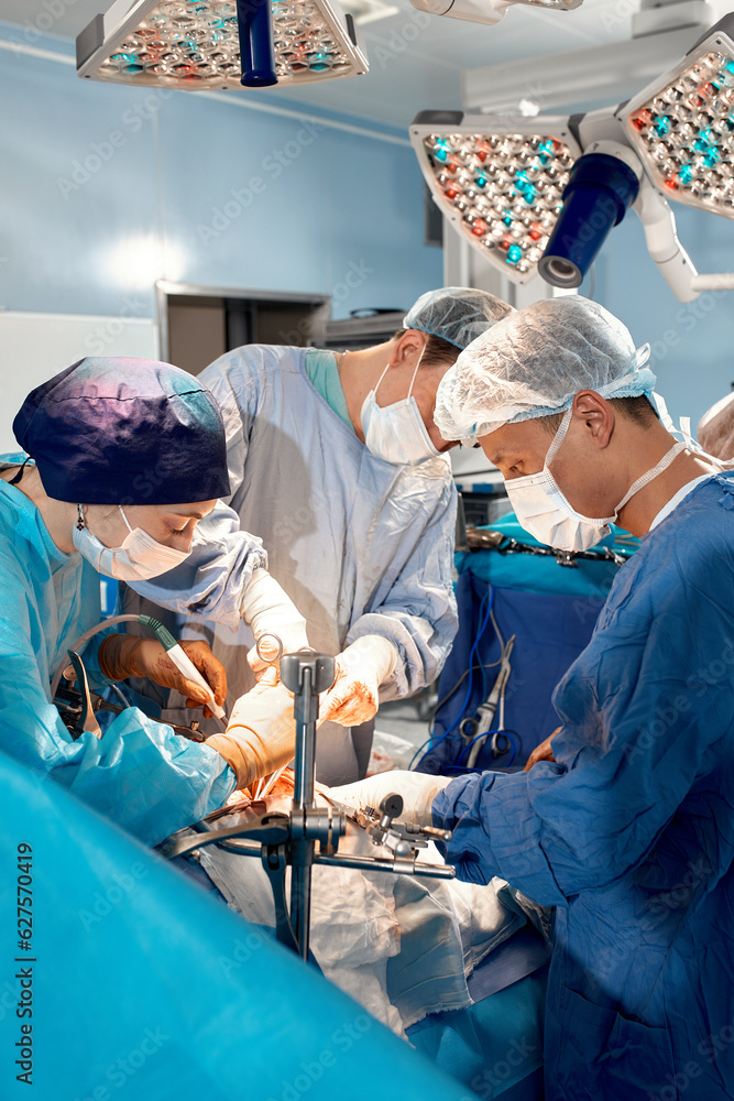 Surgeons team during complex surgical operation in a sterile operating ...