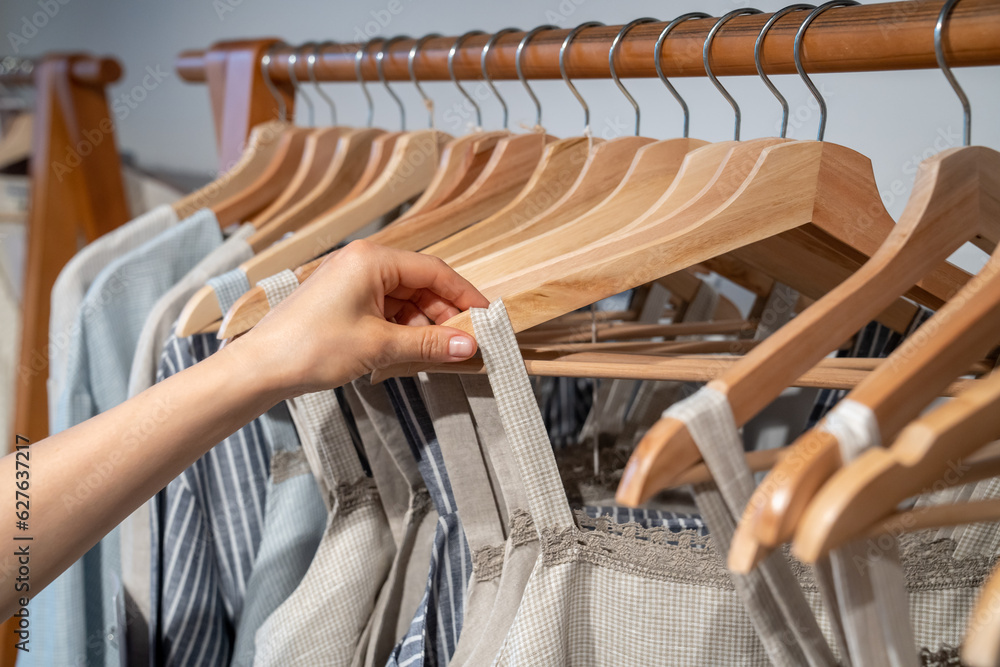 Choice of clothes made from ecological natural fabrics. Closeup of hand ...