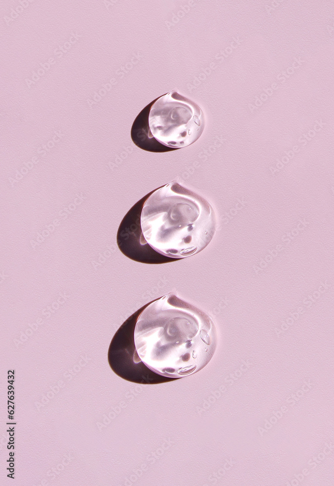 round drops of transparent gel serum on pink background Stock Photo ...