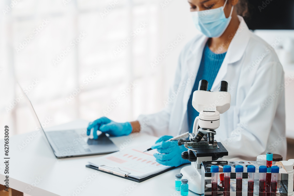 African American female technician testing blood sample in lap. blood ...