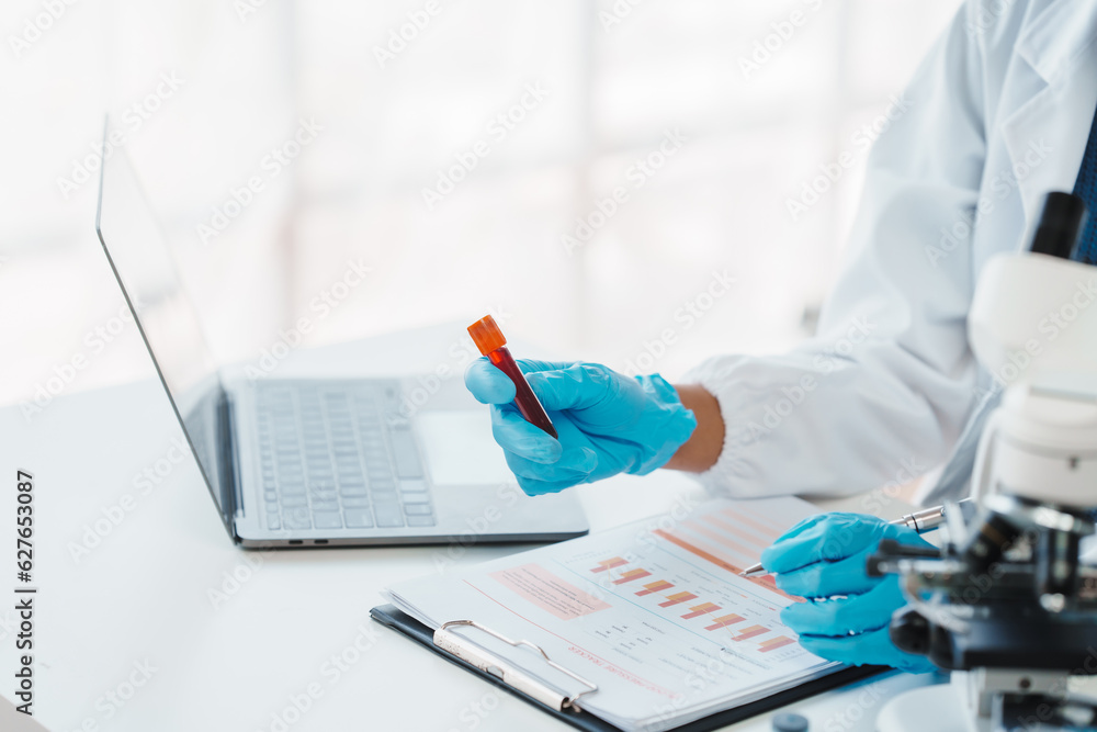 African American female technician testing blood sample in lap. blood ...