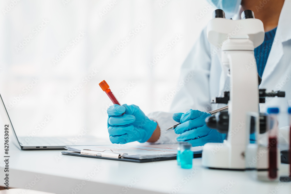 African American female technician testing blood sample in lap. blood ...