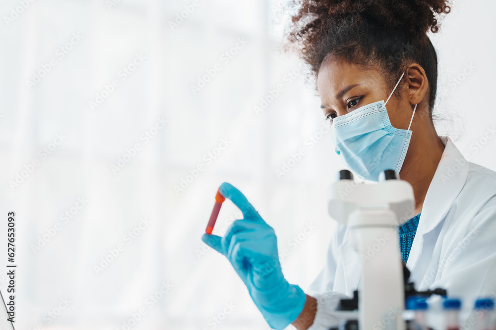 African American female technician testing blood sample in lap. blood ...