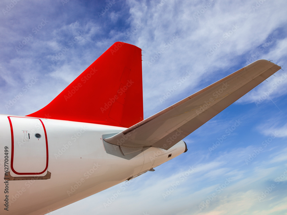 Airplane on blue sky background. Underside view of the aft, tail side ...