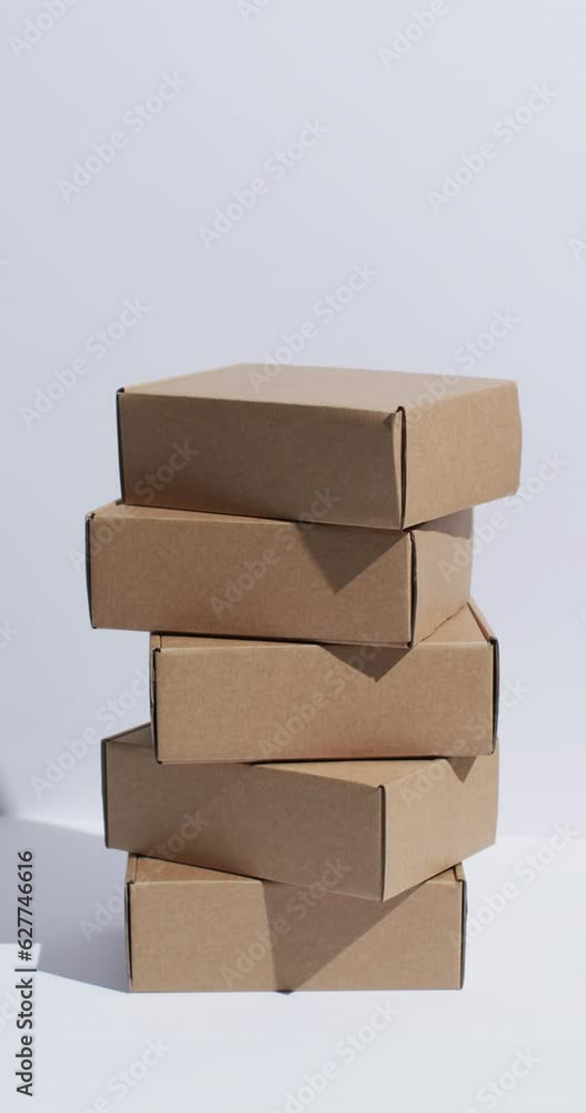 Vertical video of stacked cardboard boxes with copy space over white ...