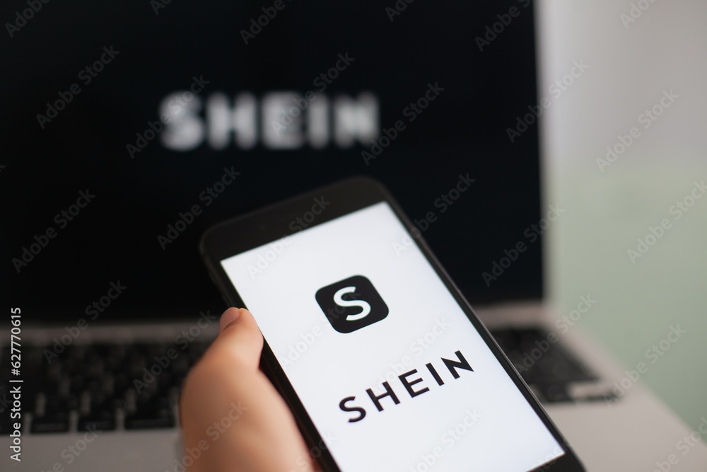 Shein logo on the screen of mobile phone. Hand holding smartphone. Fast ...
