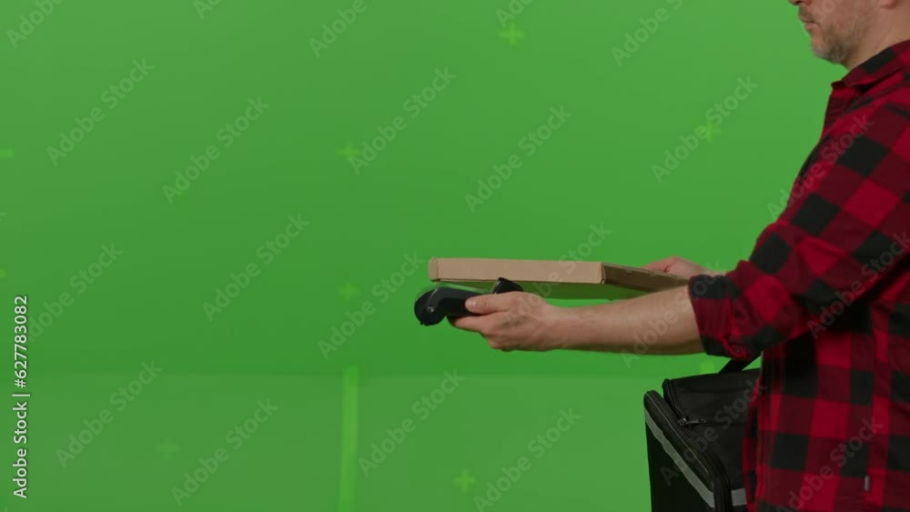 Caucasian male courier passing a box of pizza on green screen chroma ...