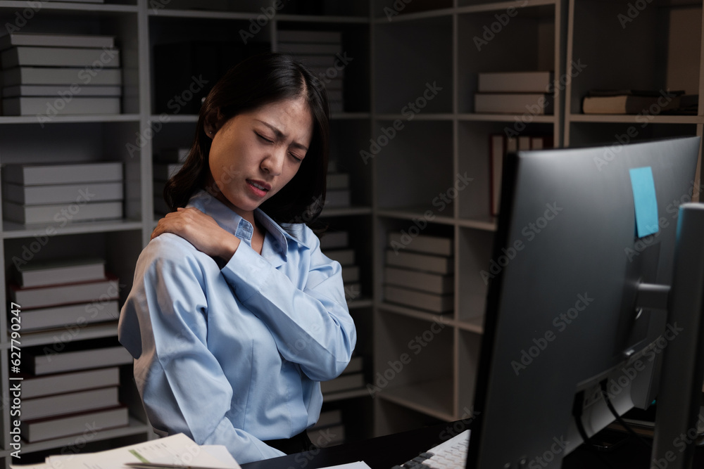 Tired and exhausted young businesswoman having a shoulder pain after ...
