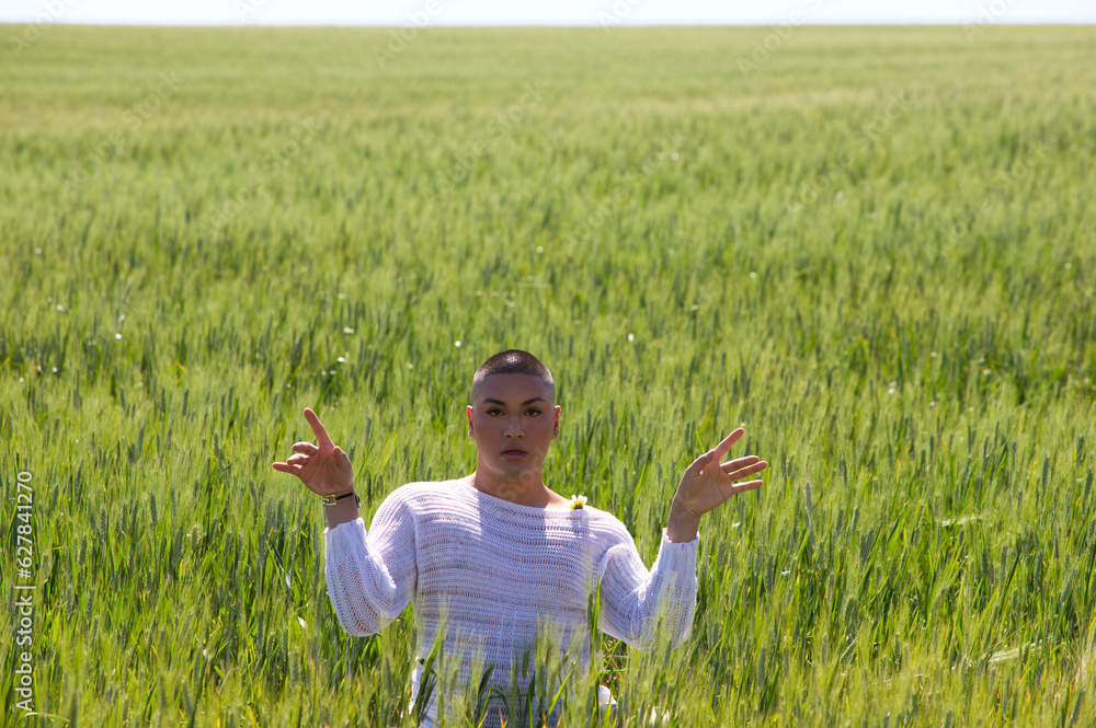 Non binary latin and young gay person has fun among the green wheat ...