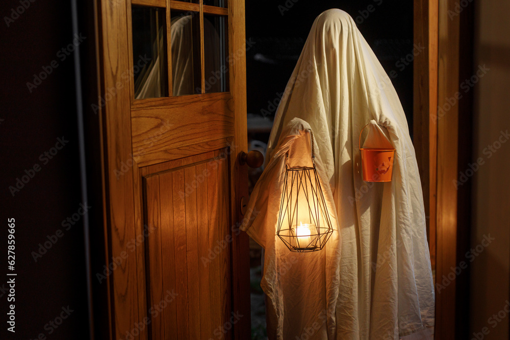 Trick or treat! Spooky ghost holding glowing lantern and halloween ...