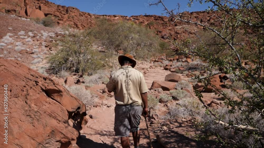 Namibian ranger hiking to Rock cravings petroglyphs at Twyfelfontein in ...