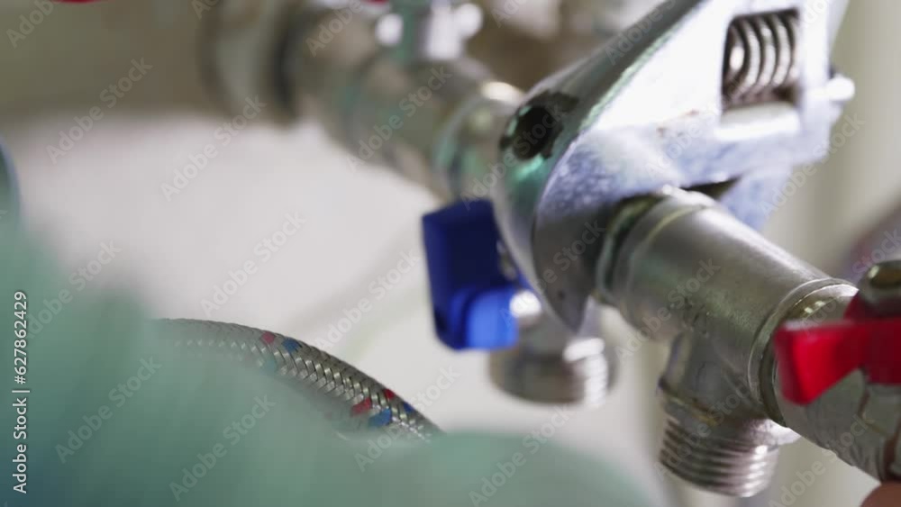 tightening the threaded connection of plumbing pipes with a wrench ...