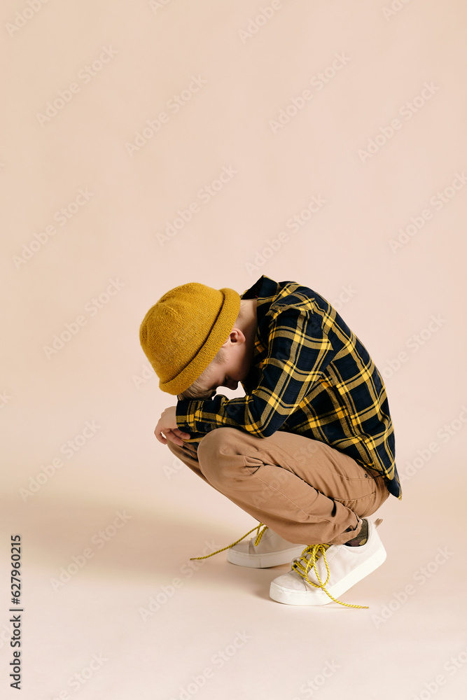Picture of frustrated teen boy sitting alone on his hunkers and hiding ...