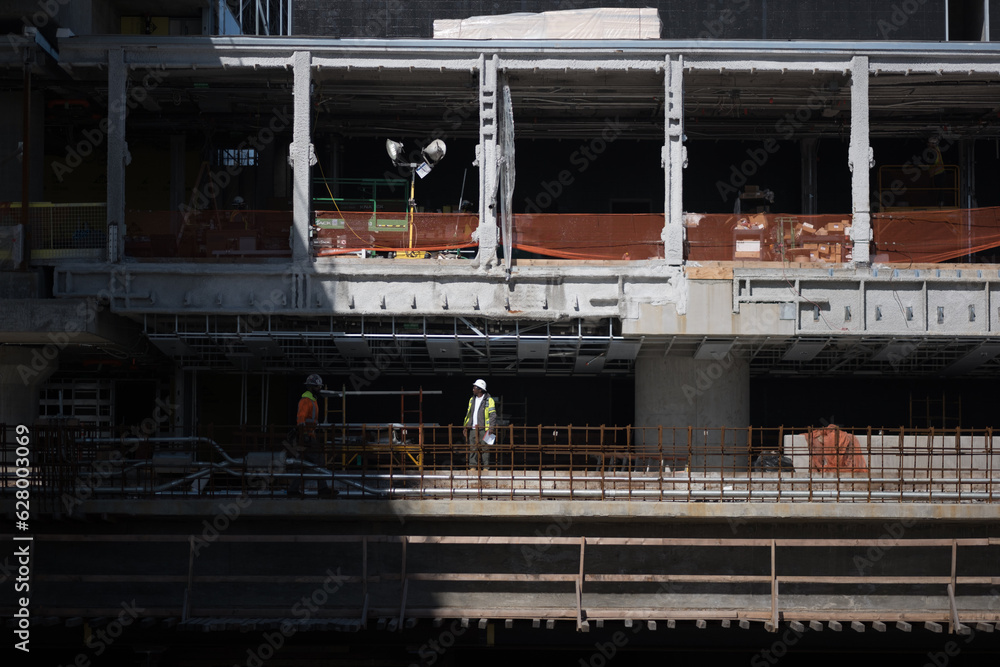 Construction workers at an unfinished building, part of a construction ...