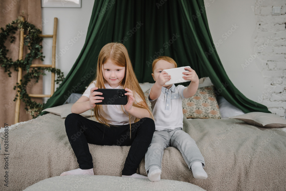 Children playing mobile device video game. Cute little boy, girl using ...
