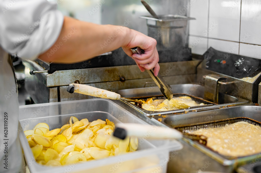 Chef cooking delicious potato chips in hot oil on kitchen Stock Photo ...