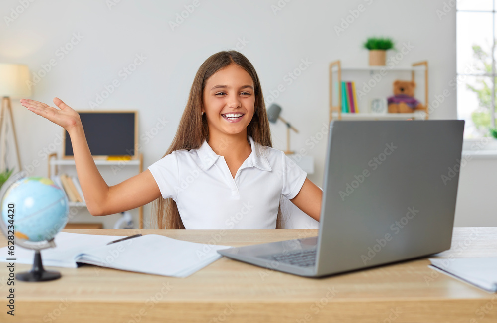 Cute school girl sitting at laptop computer learning online. Photo of ...