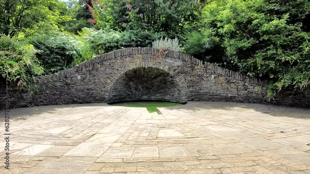 Circling stone humpback bridge in public park from left to right in ...