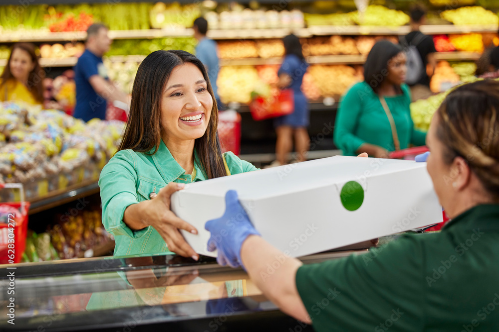 Baker handing female customer custom cake order from bakery counter in ...