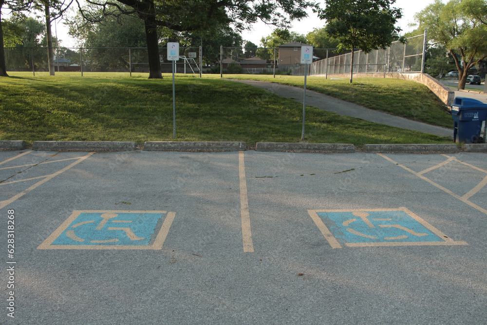 two handicap parking spots with blue and yellow handicap logo inside ...